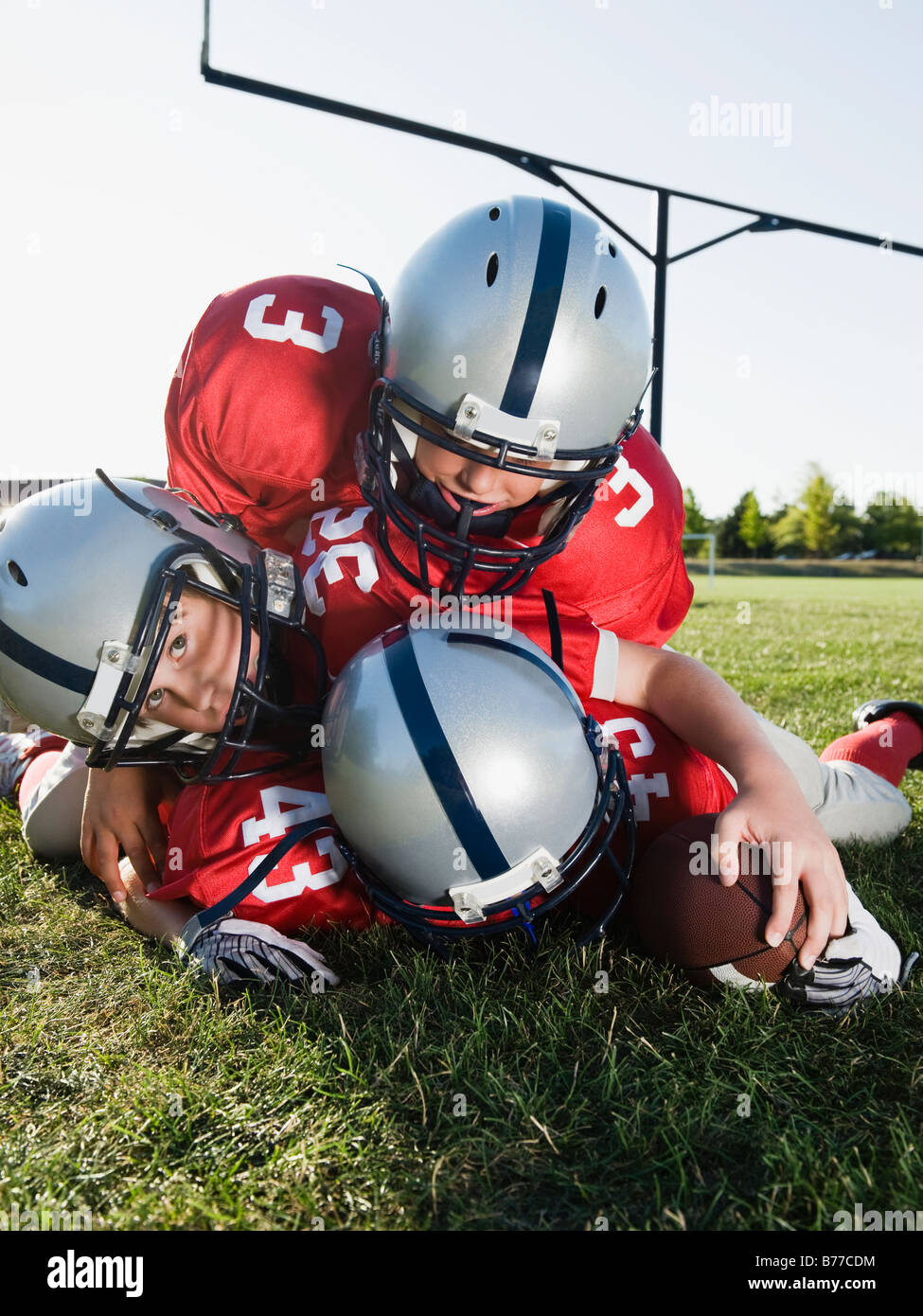 Football players piled on ball Stock Photo - Alamy