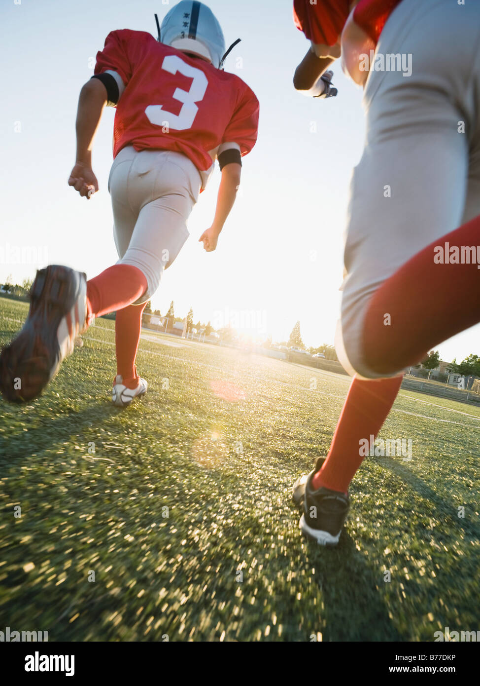 Football players running on field Stock Photo - Alamy