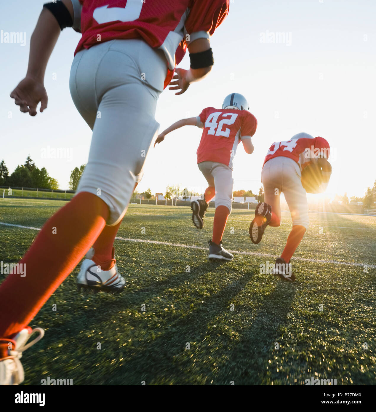 Football players running on field Stock Photo - Alamy