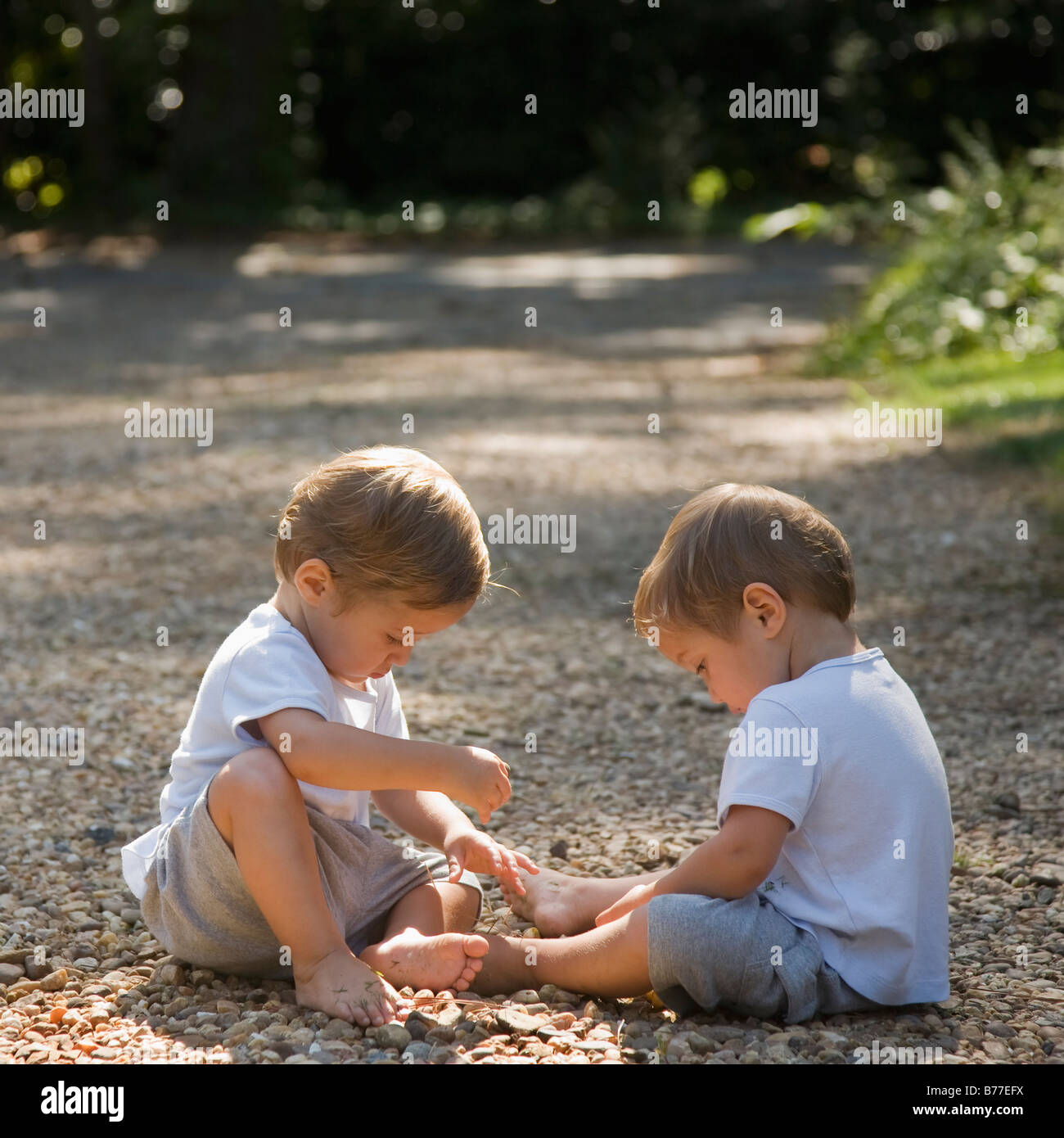 Toddler boys playing pebbles Stock Photo - Alamy