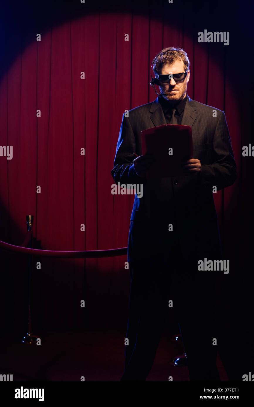 Bouncer looking guest list Stock Photo - Alamy