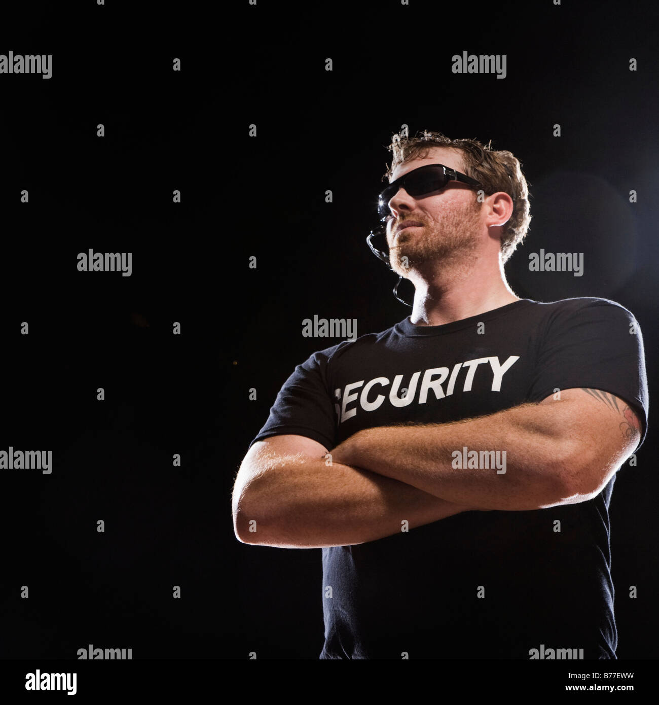 Security guard standing arms crossed Stock Photo - Alamy