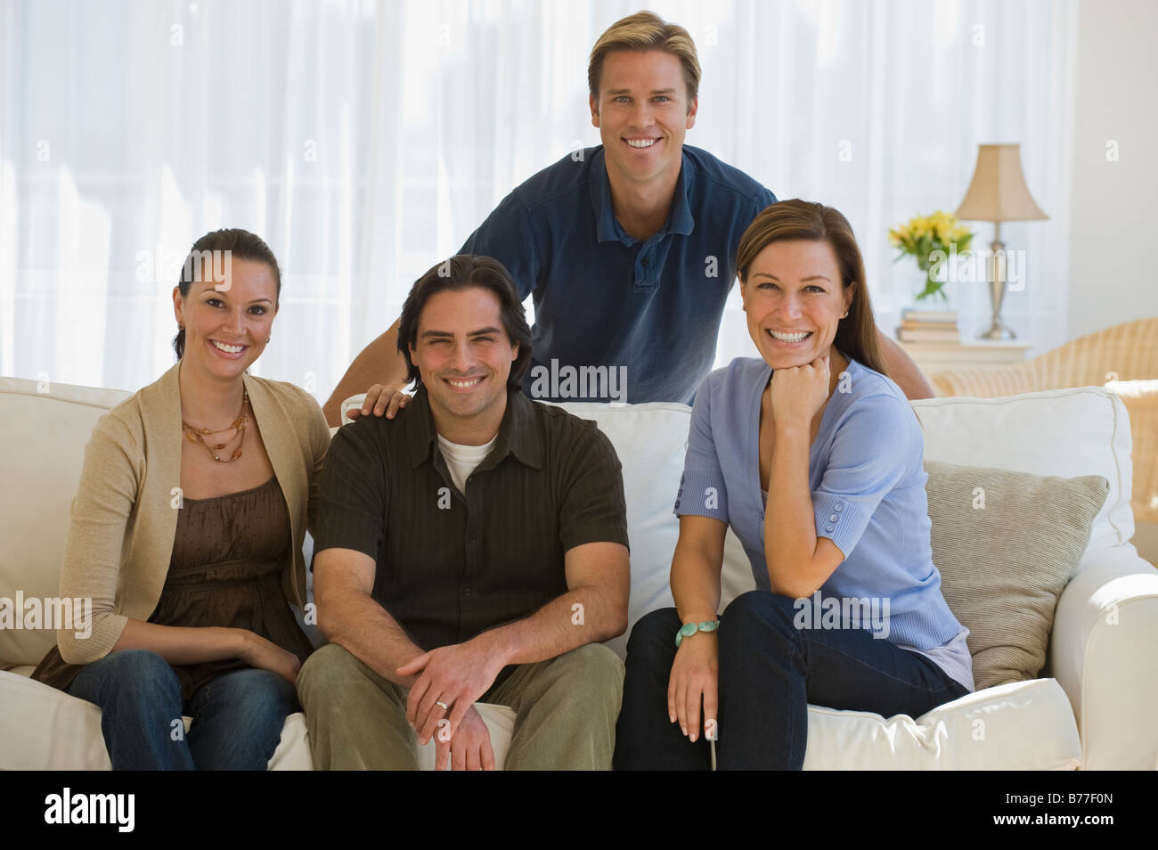 Portrait of couples sitting on sofa Stock Photo - Alamy