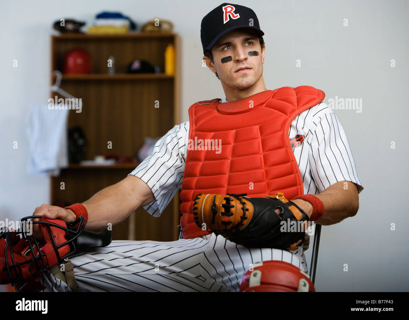 Baseball catcher sitting locker room looking pensive Stock Photo - Alamy