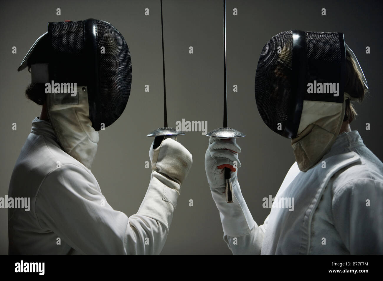 Fencers masks facing off fencing foils Stock Photo - Alamy