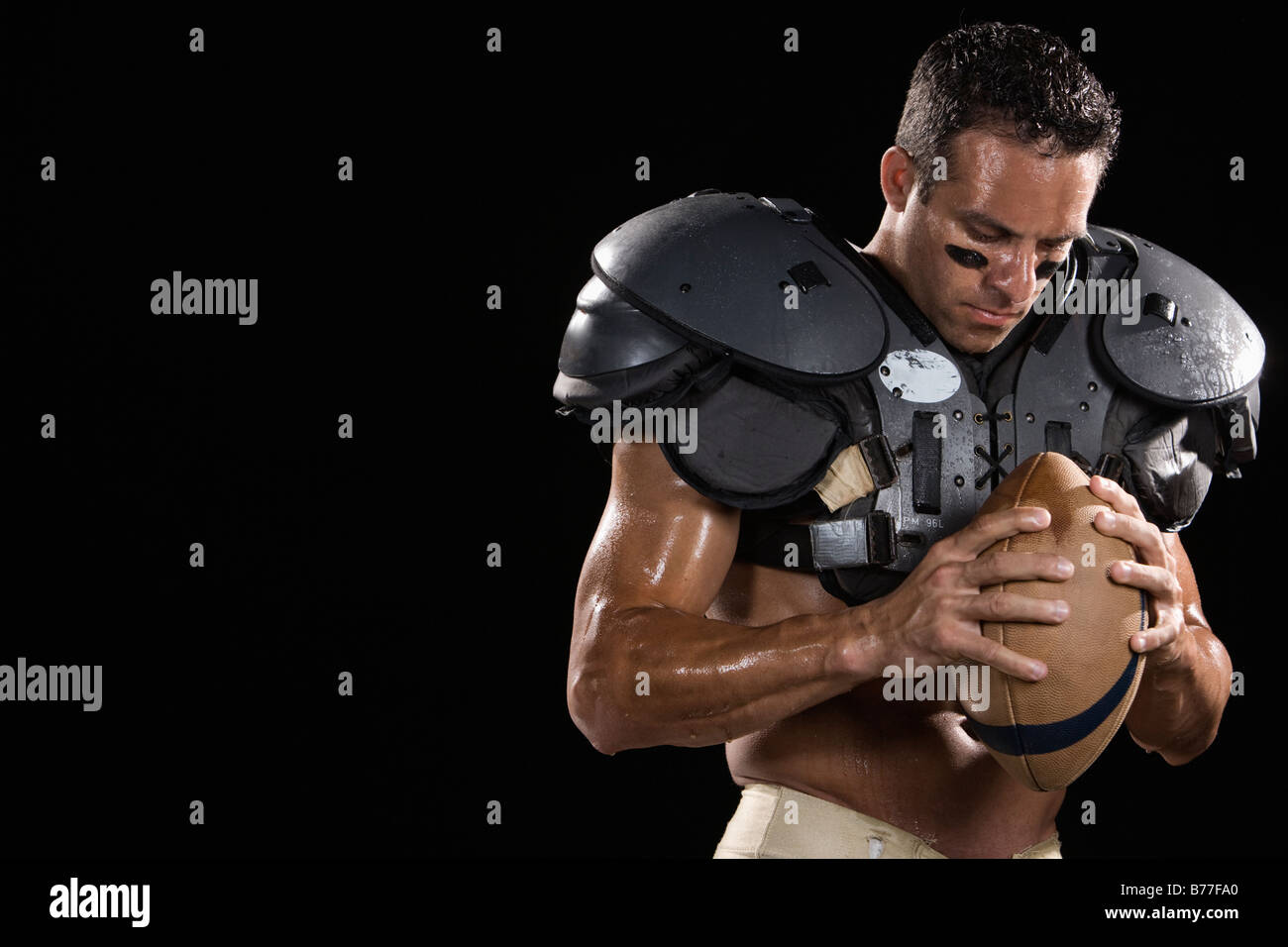 Football player wearing protective gear and holding football Stock ...