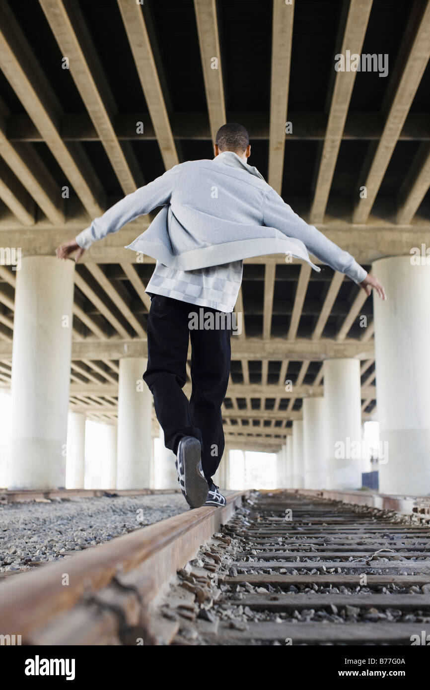 Man balancing on railroad tracks Stock Photo - Alamy