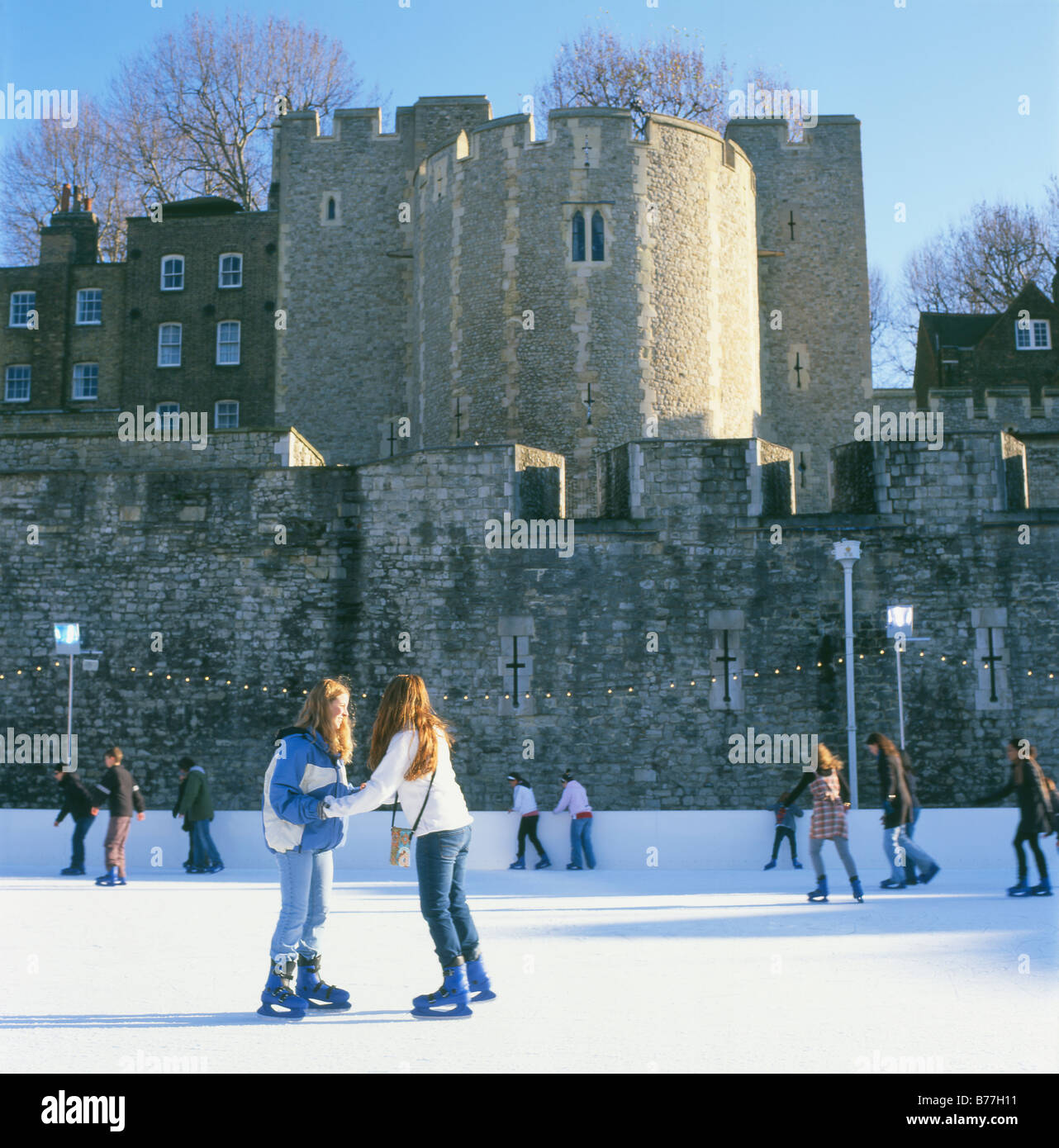 Young skaters ice skating outdoors on the moat ice skating rink Tower ...