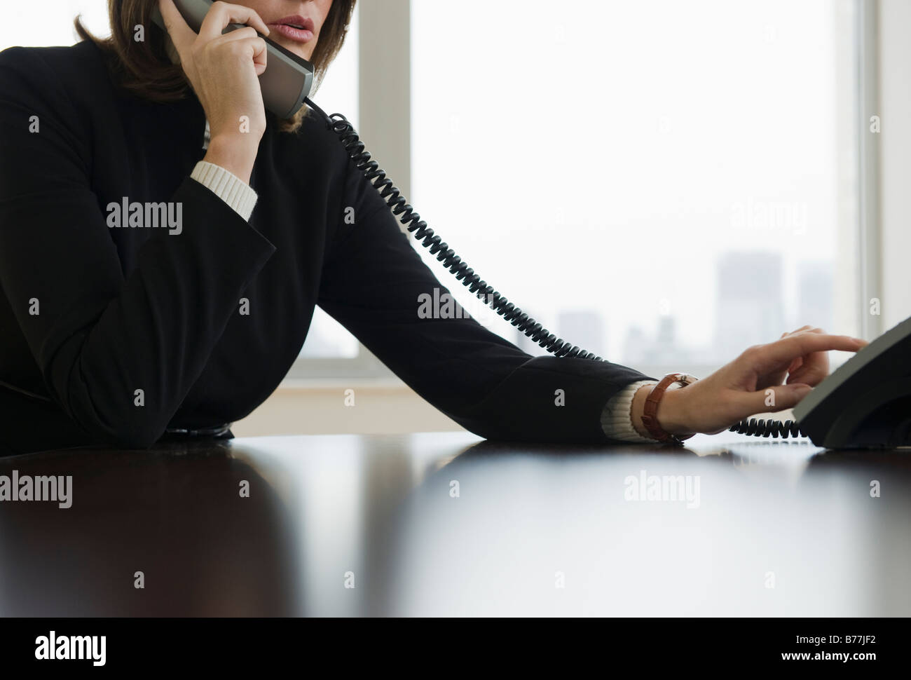 Woman dialing telephone office Stock Photo - Alamy