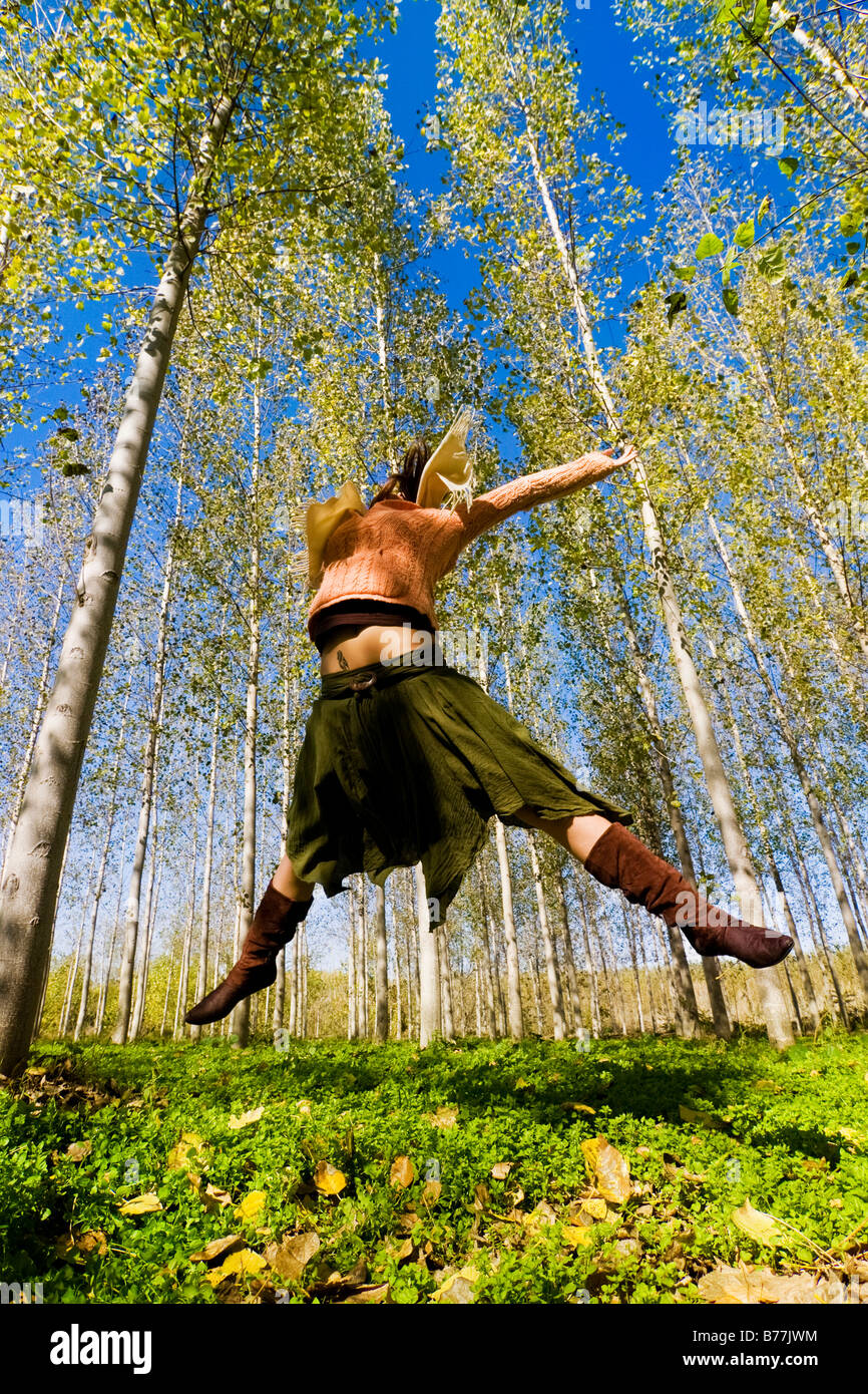 Young woman jumping in the forest Stock Photo - Alamy
