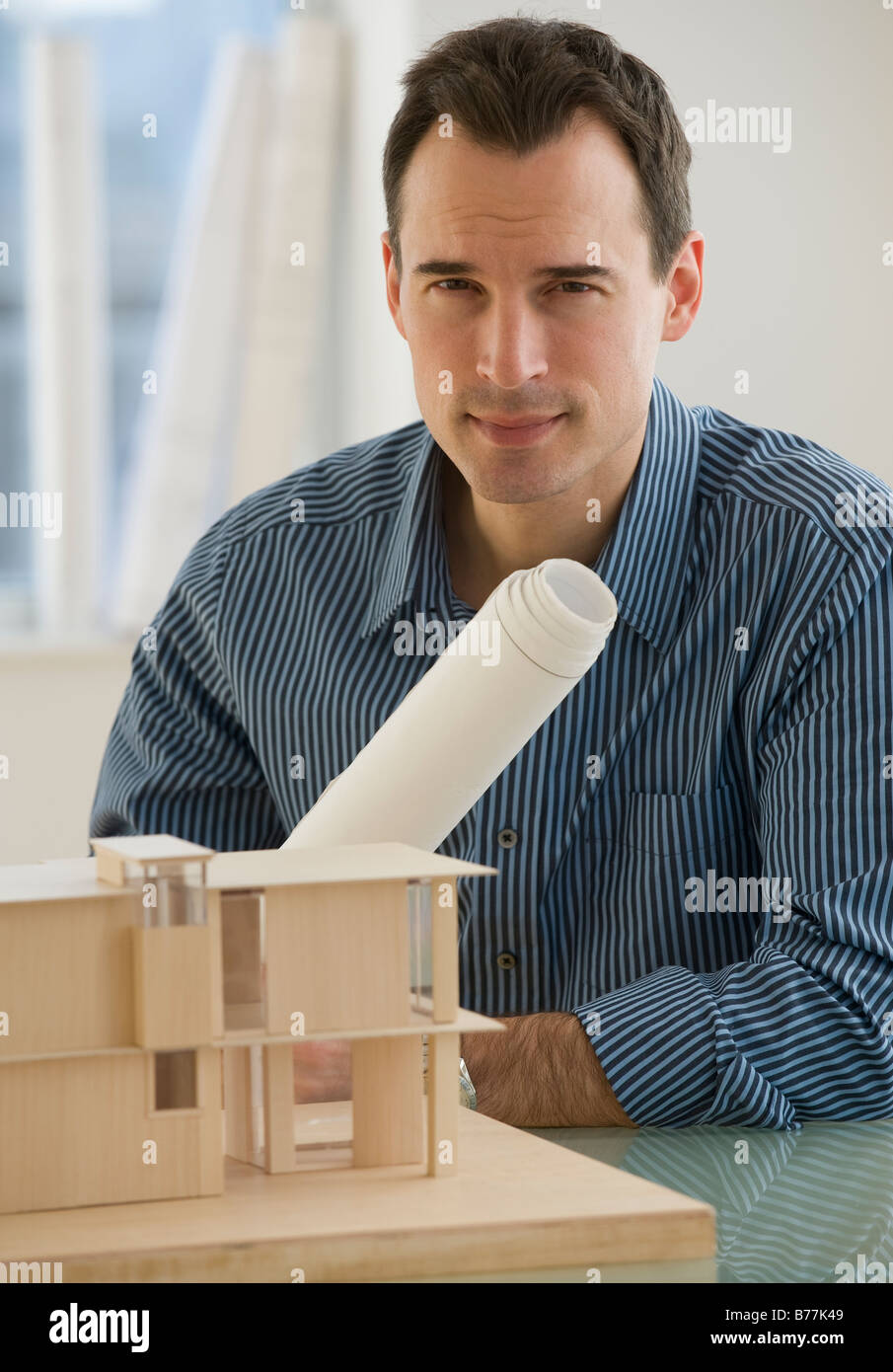 Portrait of architect blueprints and building model Stock Photo - Alamy