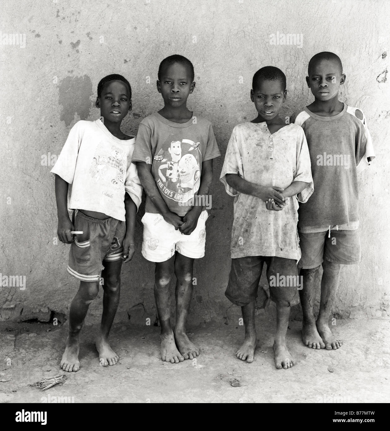 Four kids standing next to wall Stock Photo - Alamy