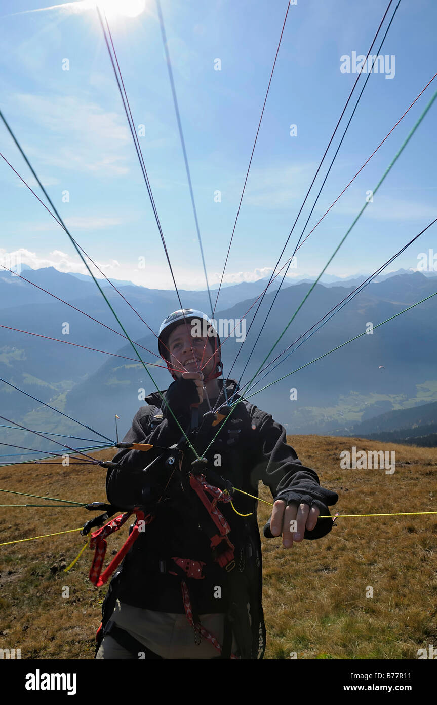 Paraglider preparing for takeoff, holding the lines, testing the wing ...