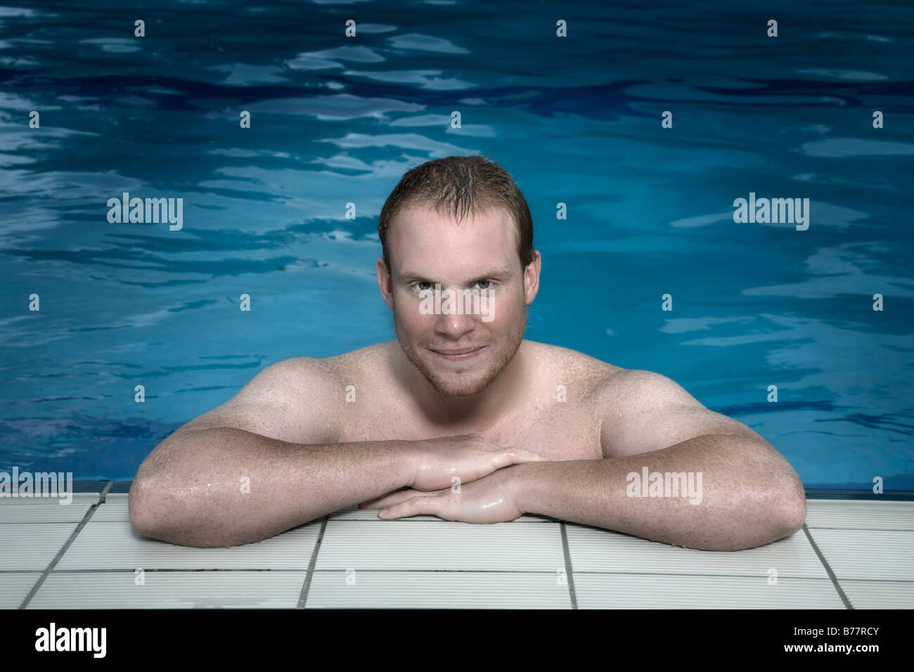 Young man leaning on the edge of a swimming pool Stock Photo - Alamy