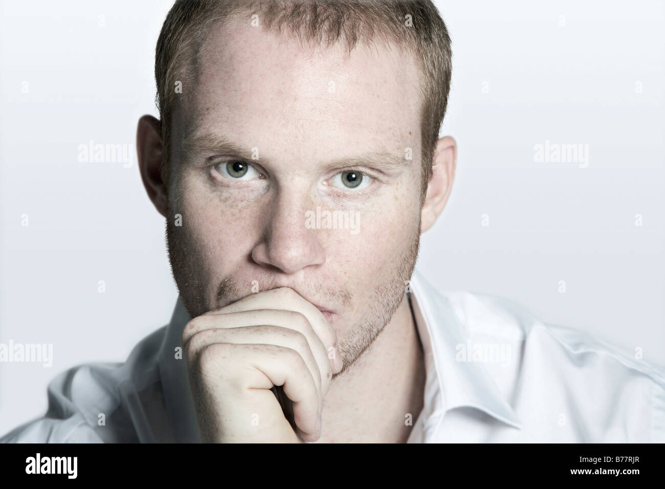 Pensive young man looking into the camera Stock Photo - Alamy