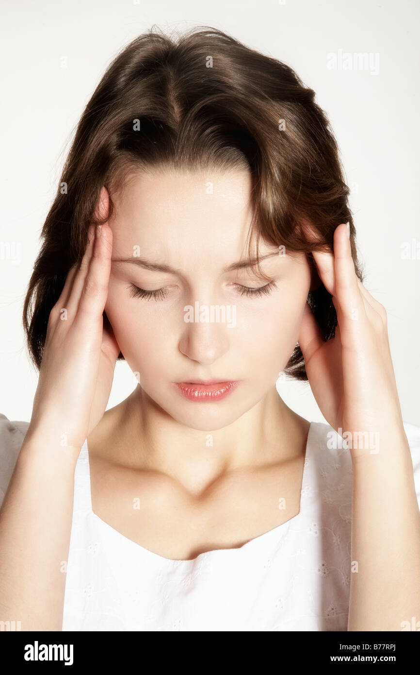 Young brunette woman massaging her temples Stock Photo - Alamy