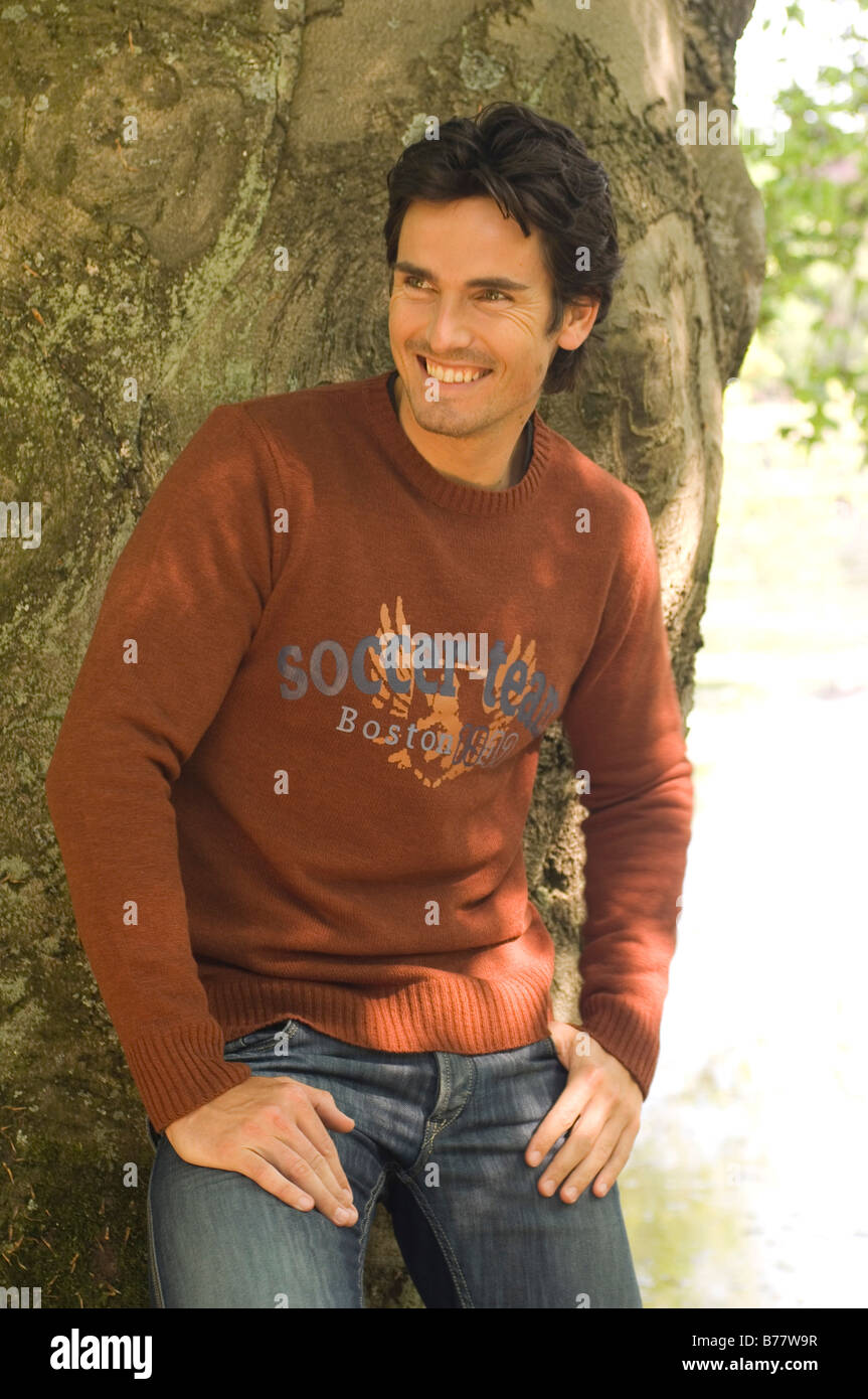 Man leaning against a tree Stock Photo - Alamy