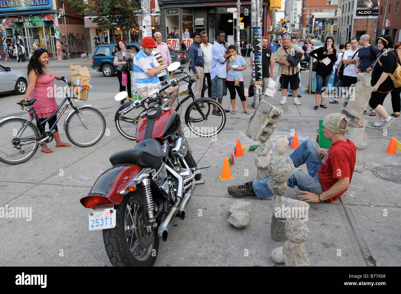 A small crowd gathers around a street artist/performer/sculptor in the ...