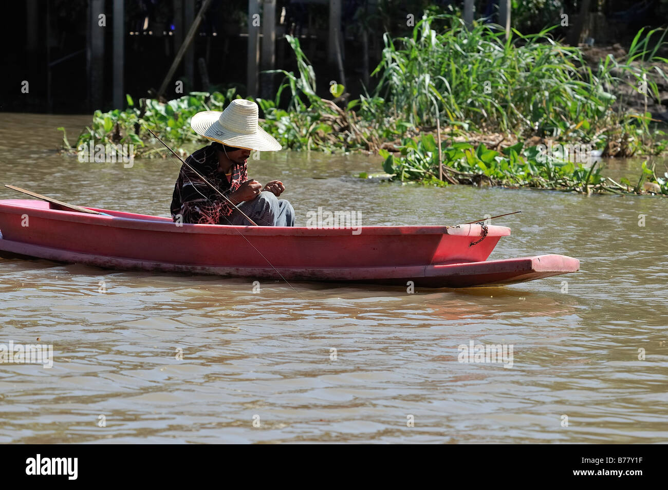 Thai man fishing on a rowing boat in the chao phraya river, Ayutthaya ...