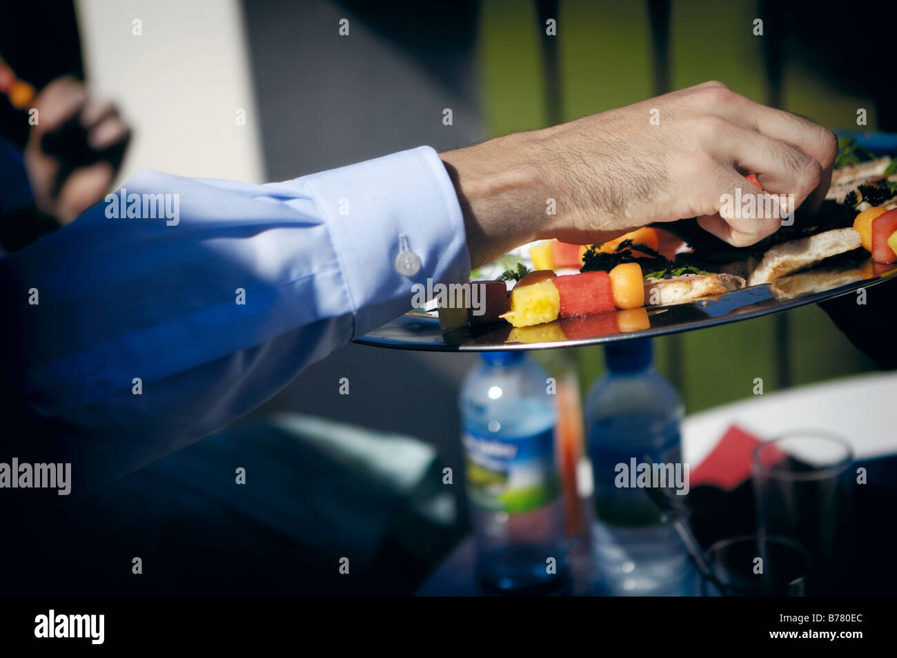 A man taking food from a tray of canapes Stock Photo - Alamy