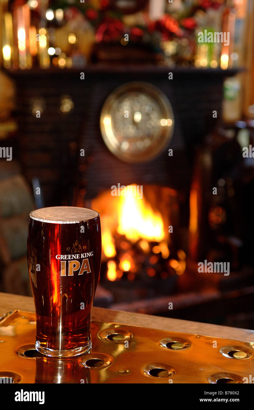 Pint of real ale with open fire behind in a traditional english country ...