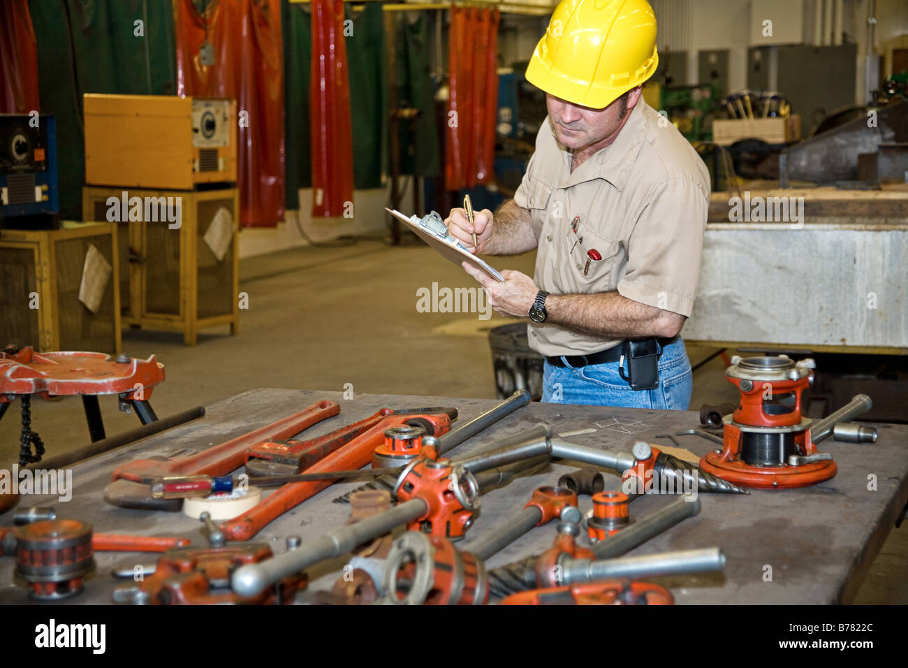 Auditor taking inventory of tools in an industrial factory Welding ...