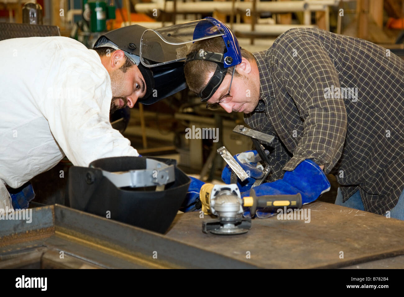 Two welders working together on a difficult metal work project ...