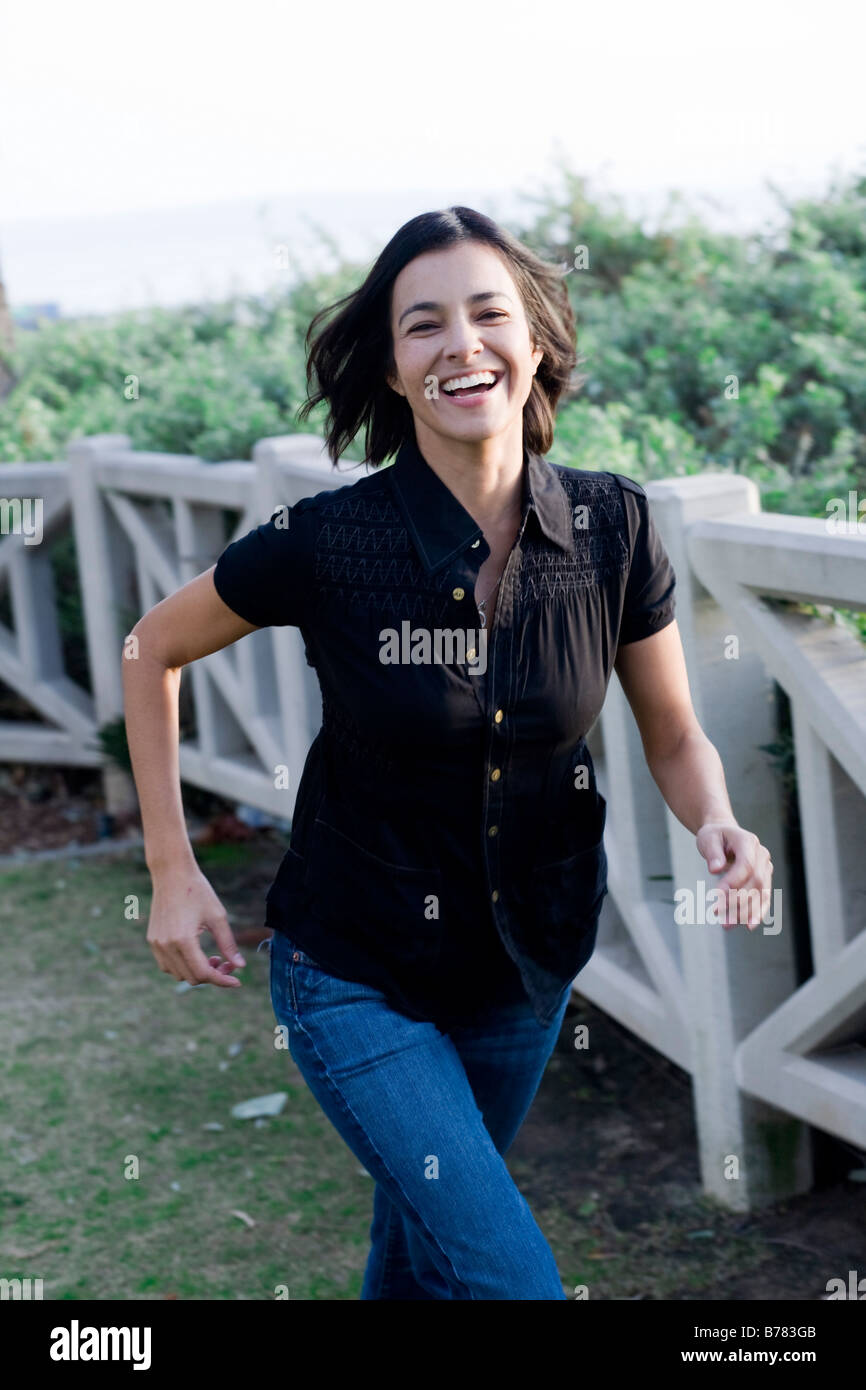Young woman running and smiling, portrait Stock Photo - Alamy