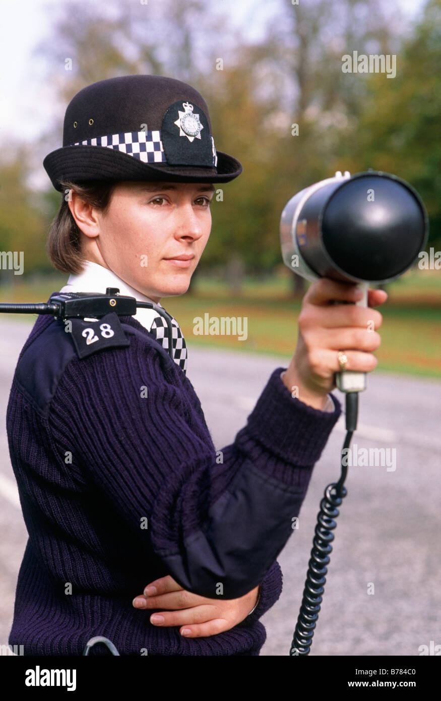 Young woman Standing by road Holding speed measuring device speed trap ...