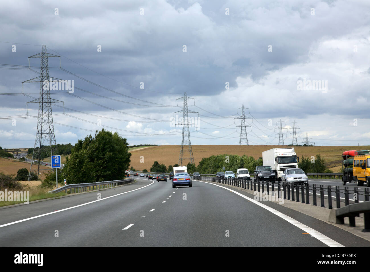 Electricity pylons over a motorway in the UK Stock Photo - Alamy