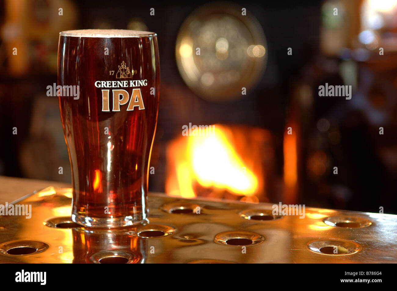Pint of real ale with open fire behind in a traditional English country ...