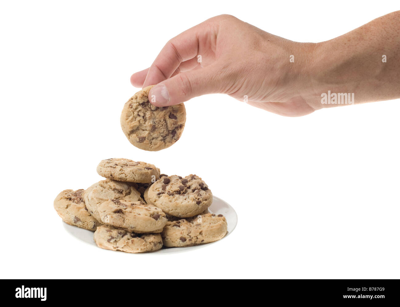 a hand about to get some chocolate chip cookies isolated on a white ...