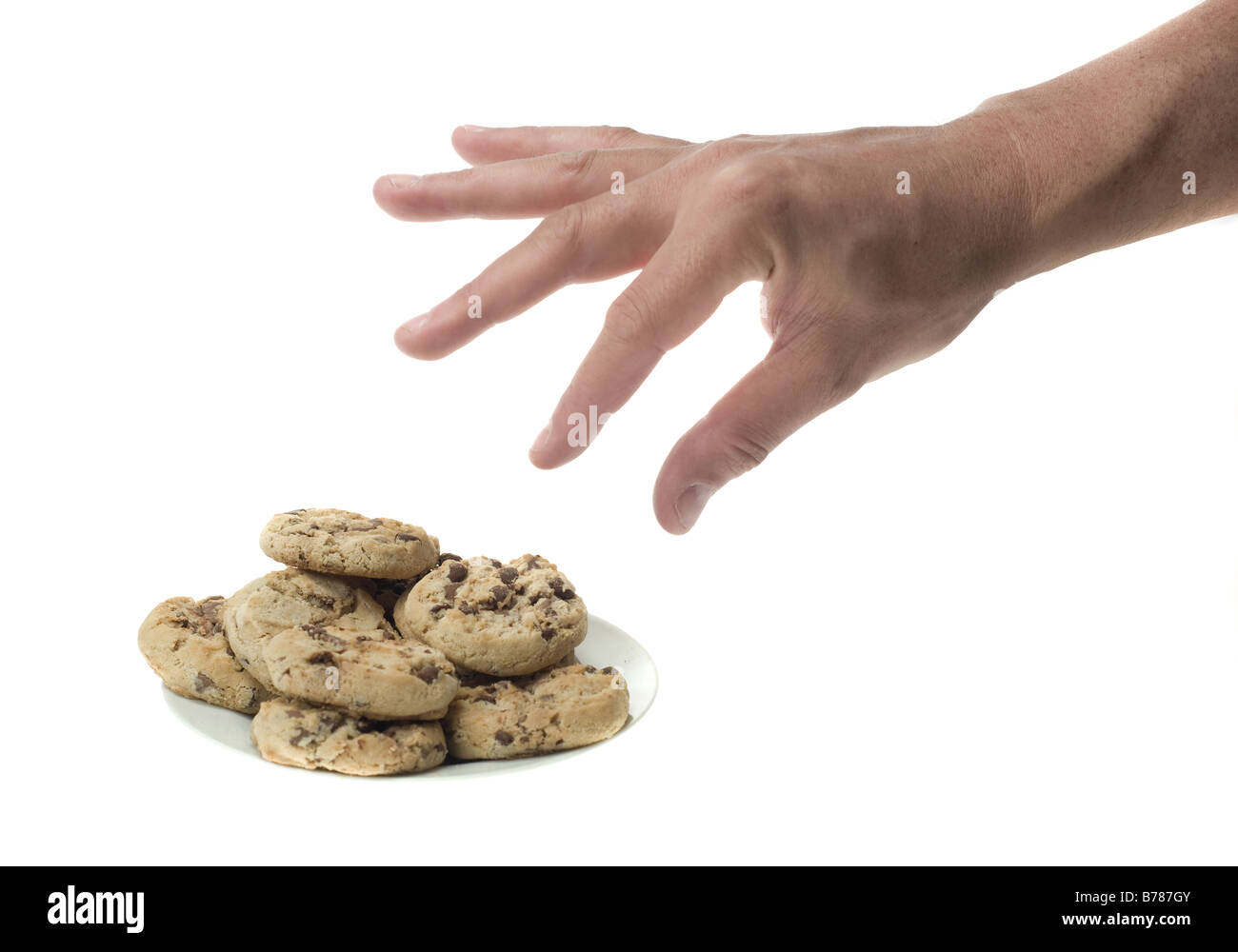 a hand about to get some chocolate chip cookies isolated on a white ...