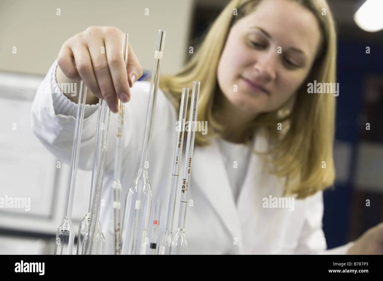 Female scientist removing volumetric pipette from a pipette rack Stock ...