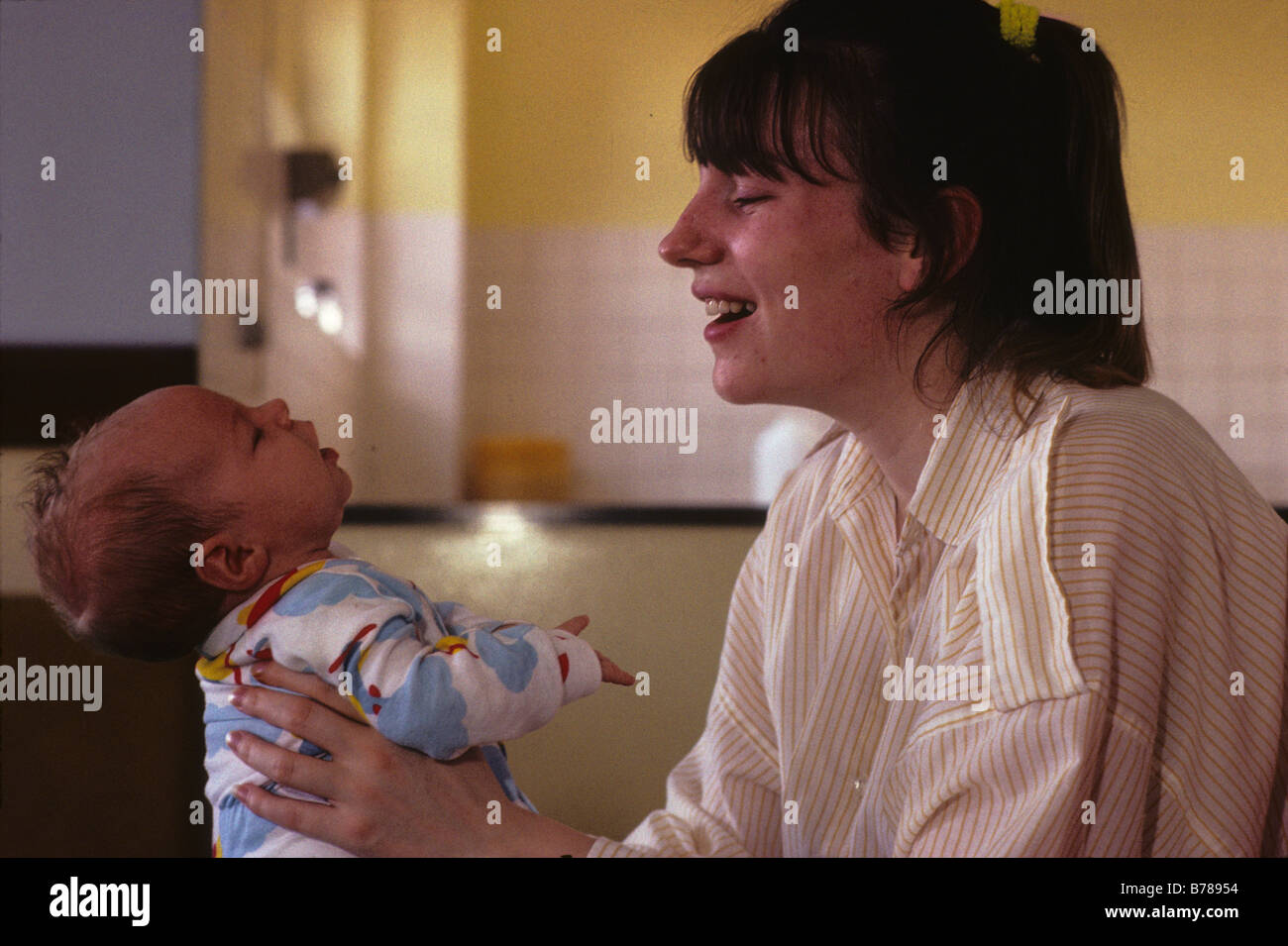 A young smiling inmate plays with her baby Stock Photo - Alamy