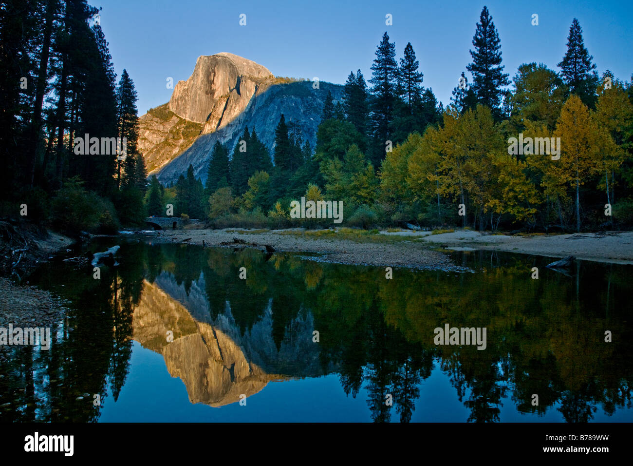 HALF DOME is reflected in the MERCED RIVER during the fall season ...