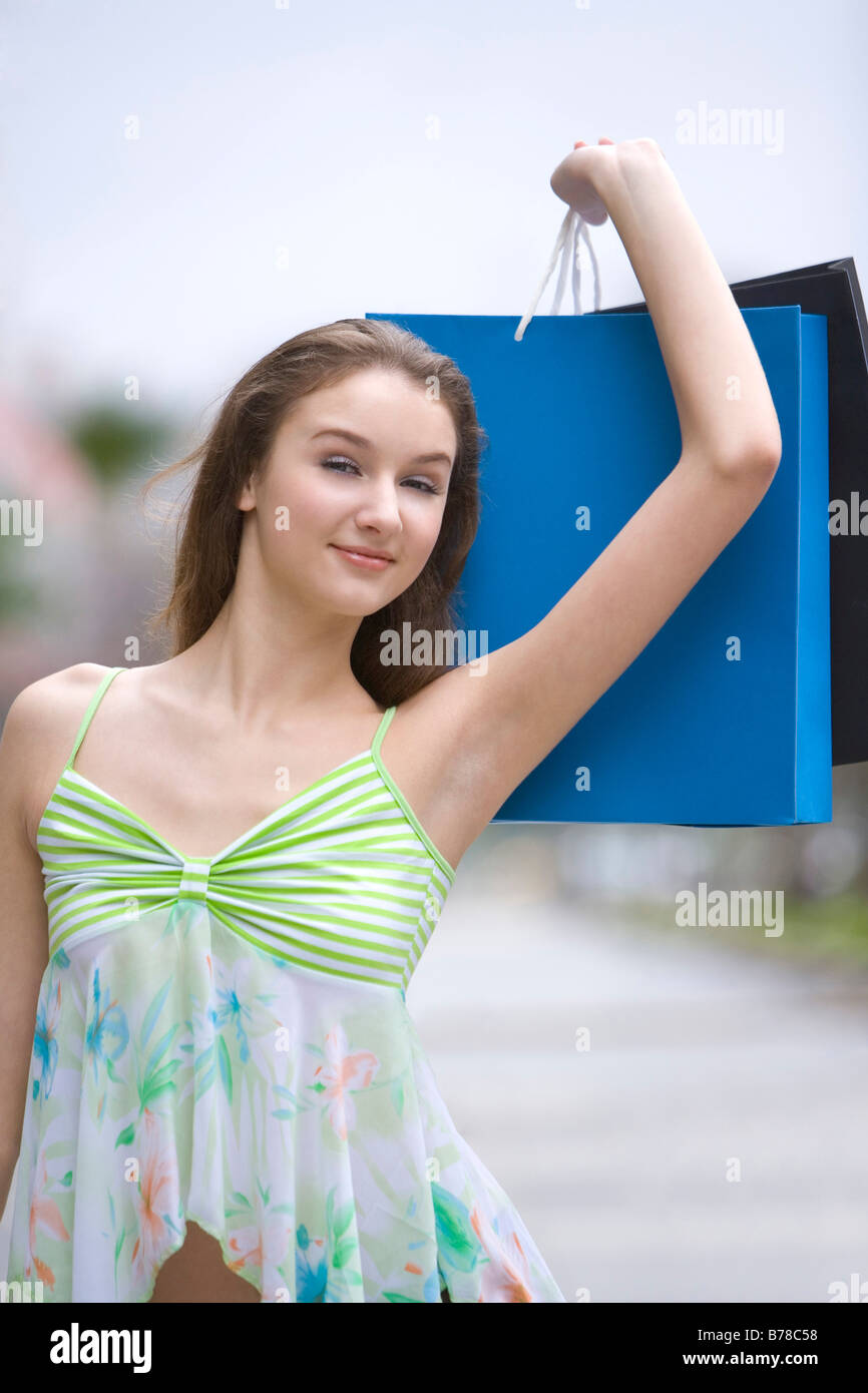 Teenage girl holding up shopping bags Stock Photo - Alamy