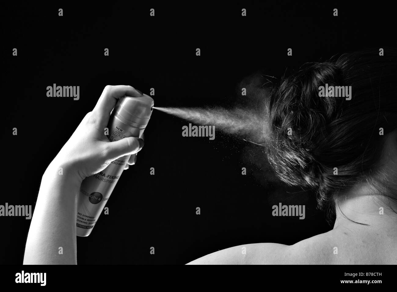 A woman sprays her hair with hairspray Stock Photo - Alamy