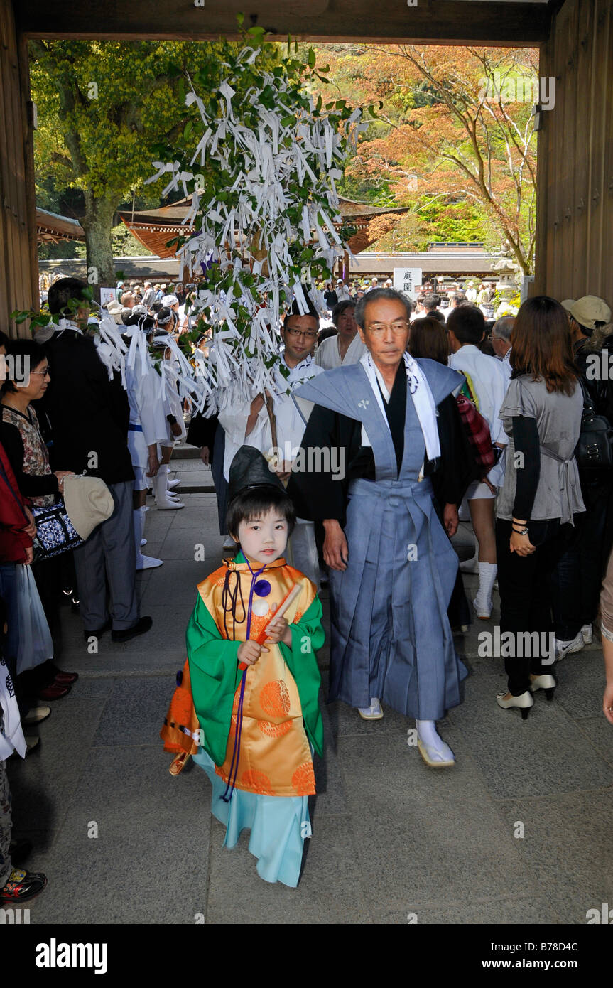 Procession attendees in traditional costume entering the shrine ...