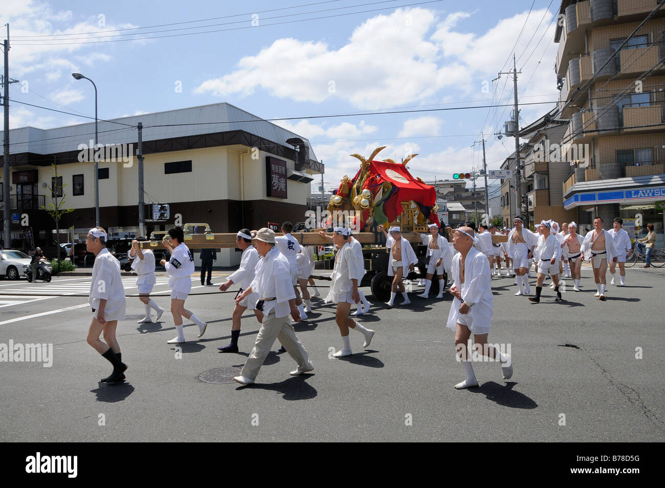 Procession crossing a big junction in the draw area of the shrine ...