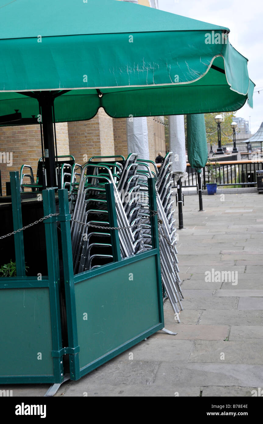 Stacked chairs of outdoor restaurant waiting for season Stock Photo - Alamy