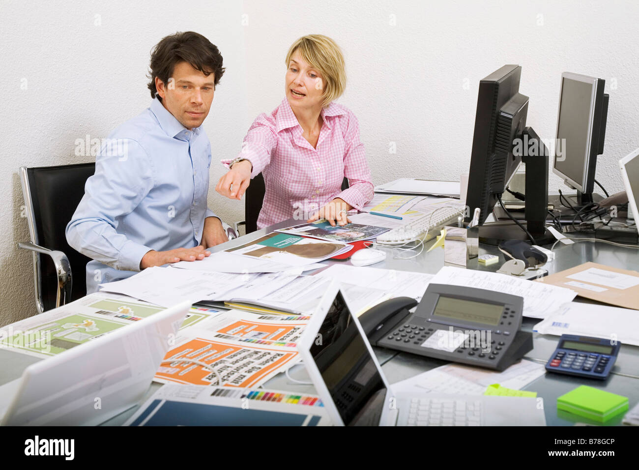 Employees of an advertising agency discussing an ad brochure and ...