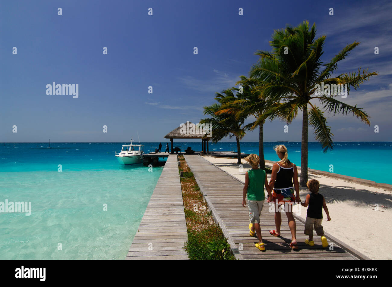 Woman and two children walking along the jetty, Laguna Resort, The ...