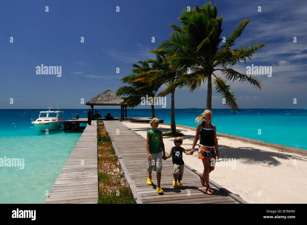 Woman and two children walking along the jetty, Laguna Resort, The ...
