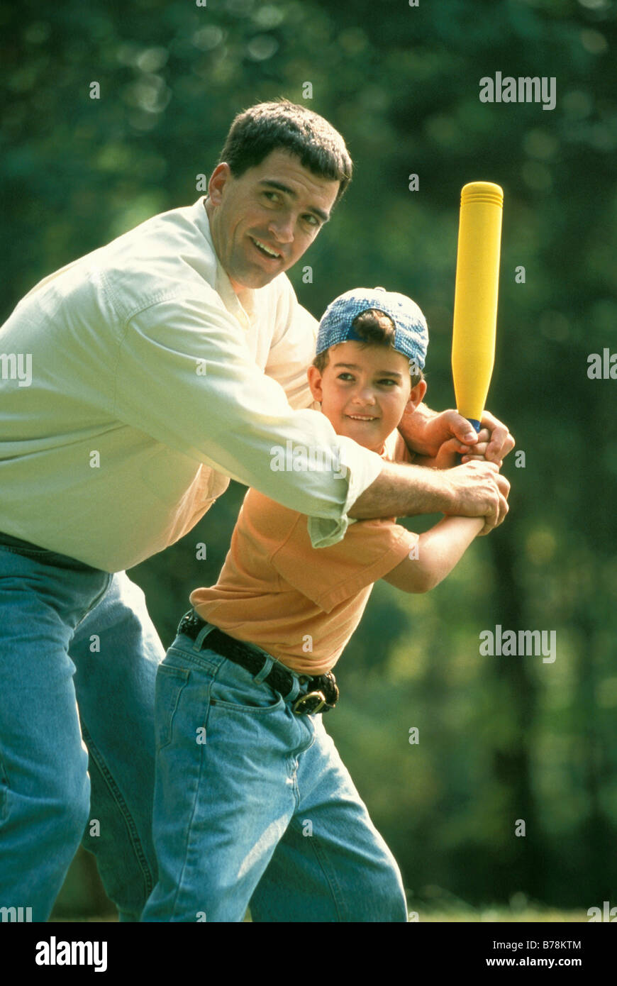 Man helps boy in baseball Stock Photo - Alamy