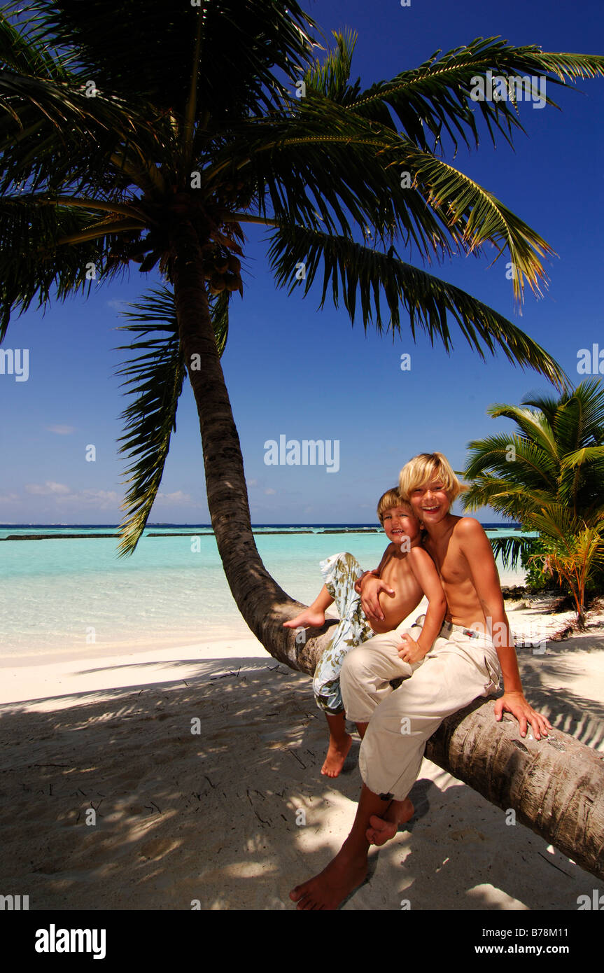 Children on a palm tree trunk in Kurumba Resort, The Maldives, Indian ...