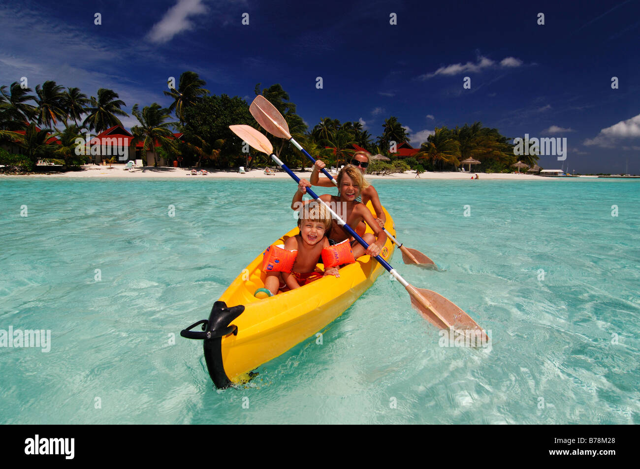 Woman with children kayaking in Kurumba Resort, The Maldives, Incian ...