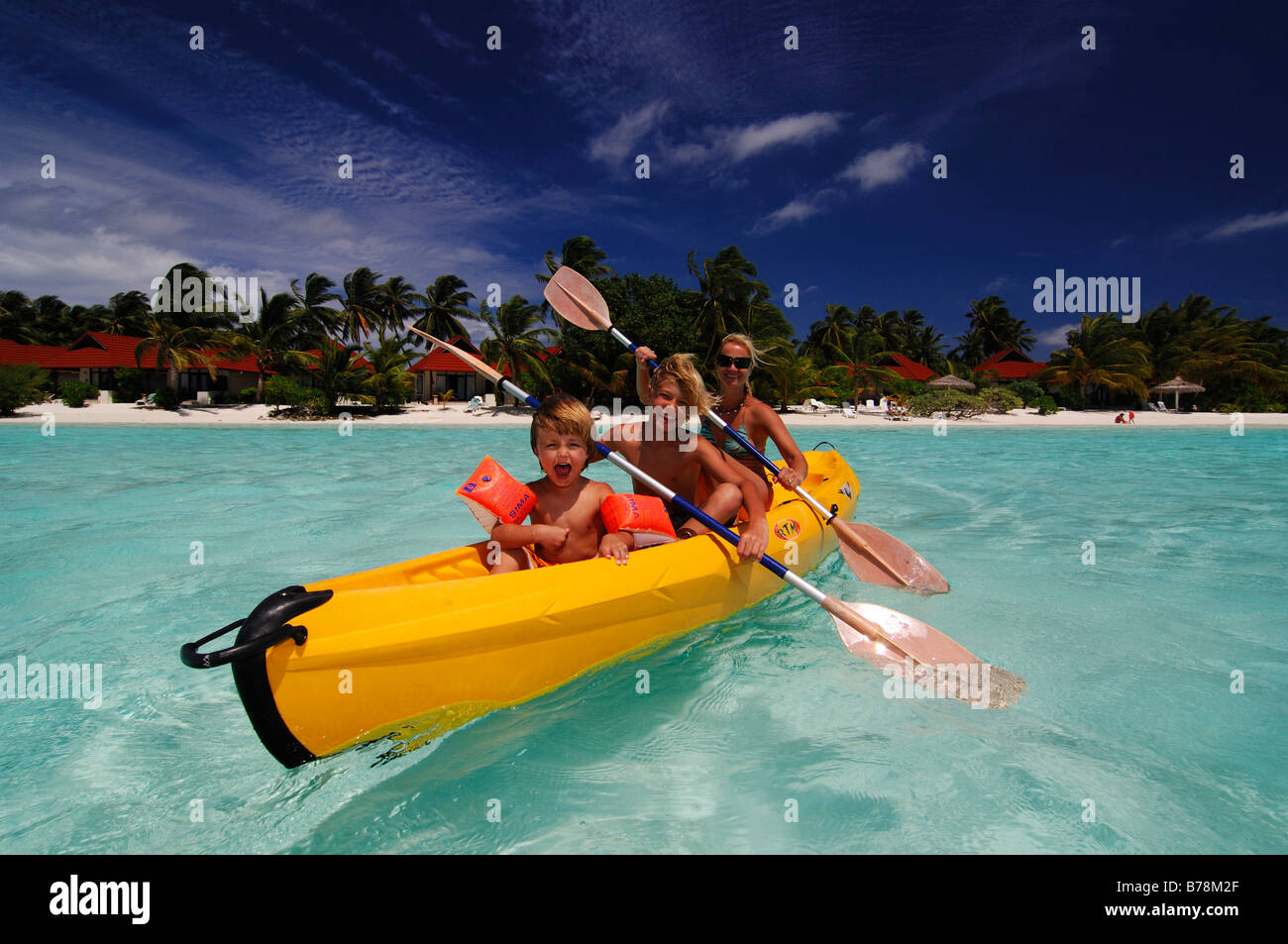 Woman with children kayaking in Kurumba Resort, The Maldives, Indian ...