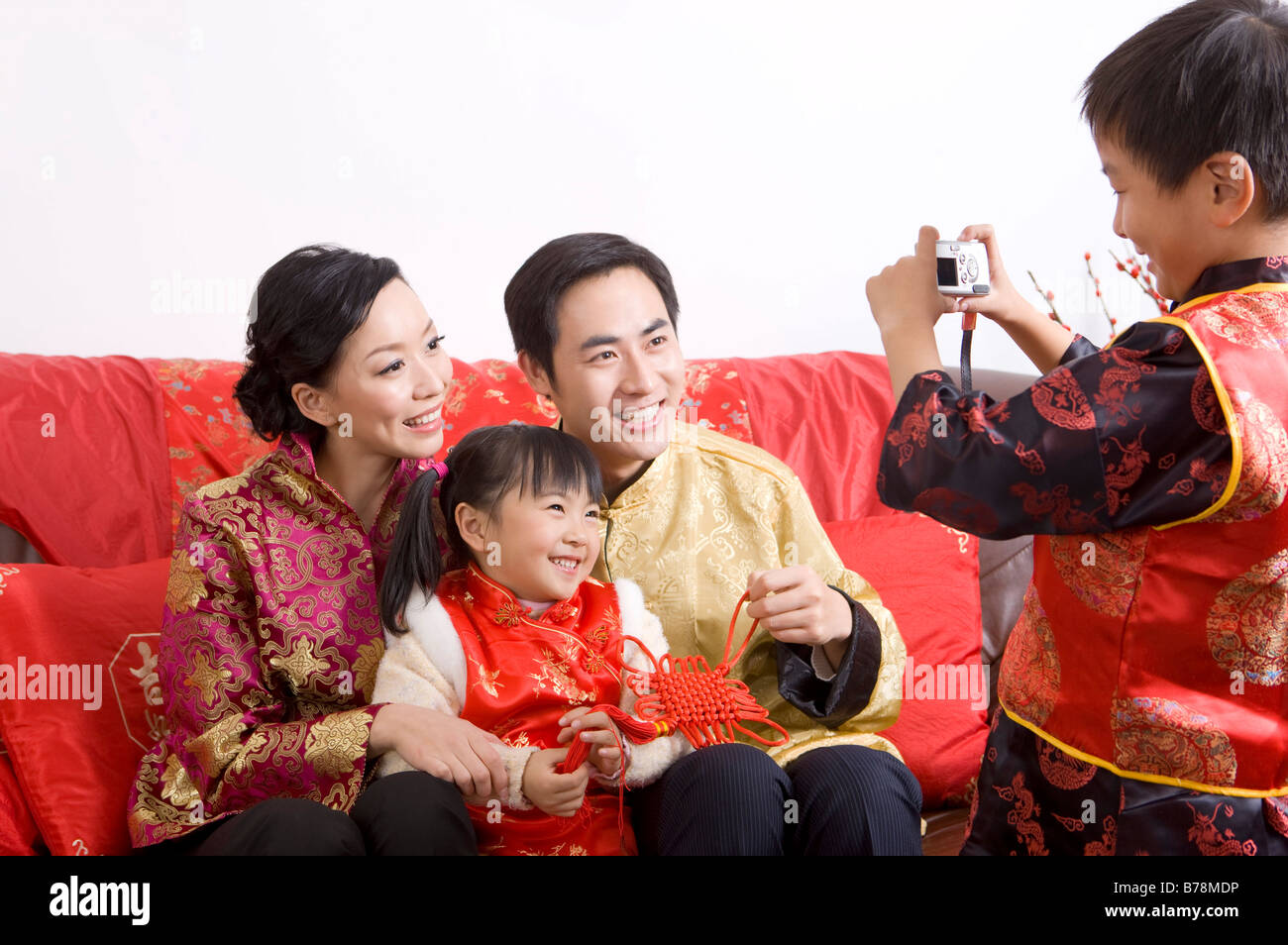 Little boy taking picture of young parents and little girl, smiling ...