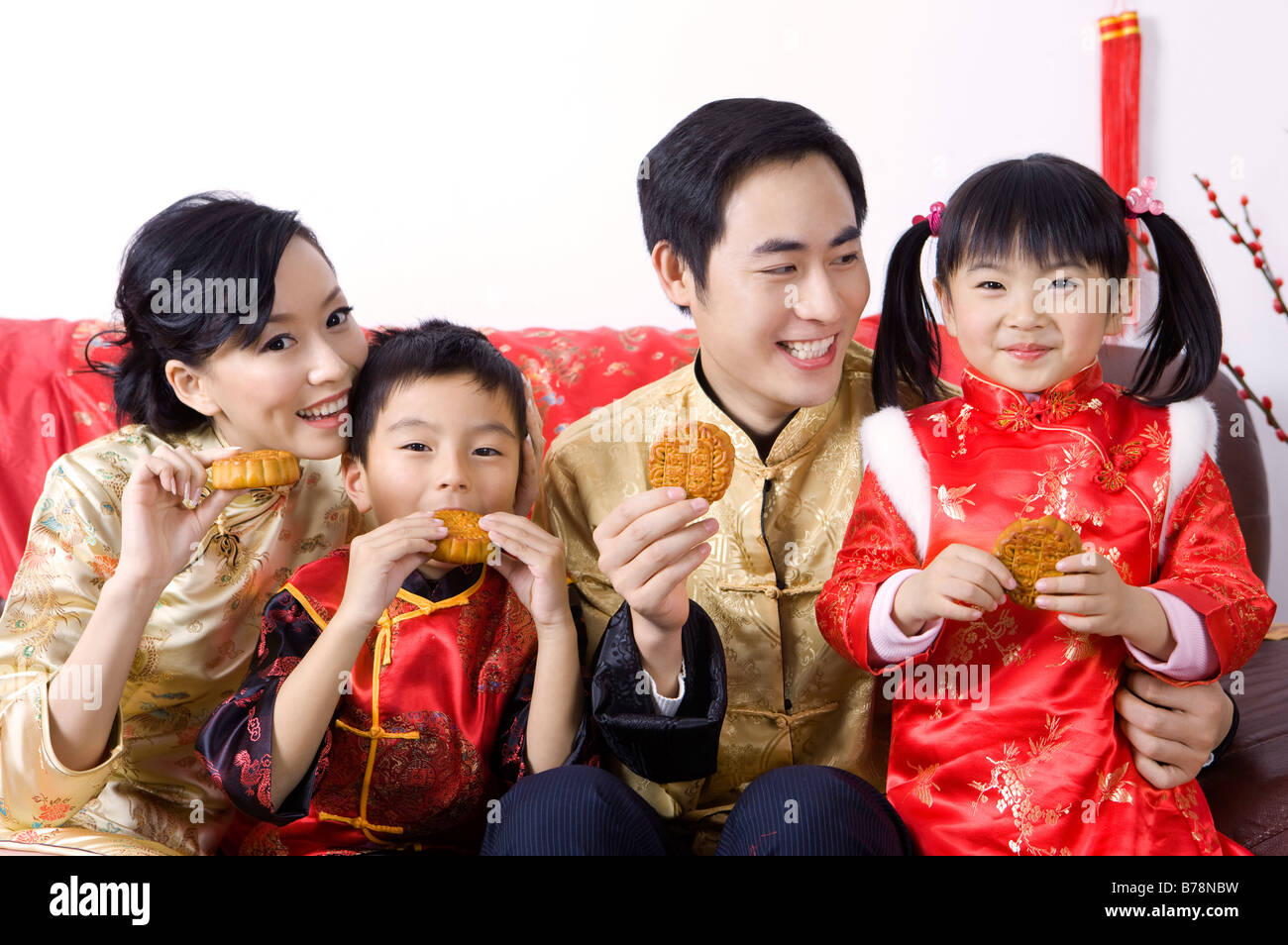 Young family with two children holding moon cakes together and smiling ...